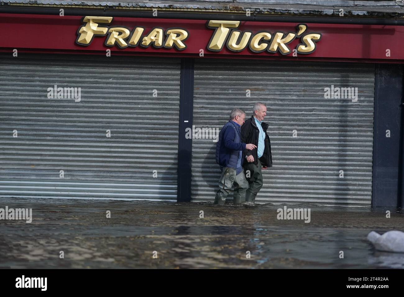 People wade through flood water as the clear up begins in Newry Town ...