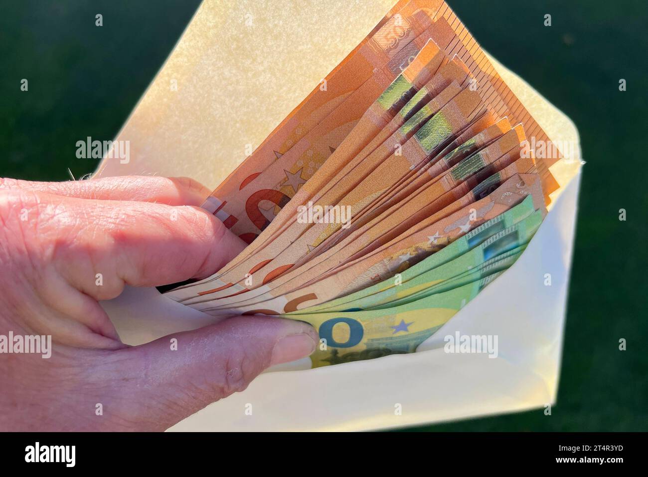 Themenbild,Symbolfoto:Hand greift Geldscheine in einem geoeffneten ...