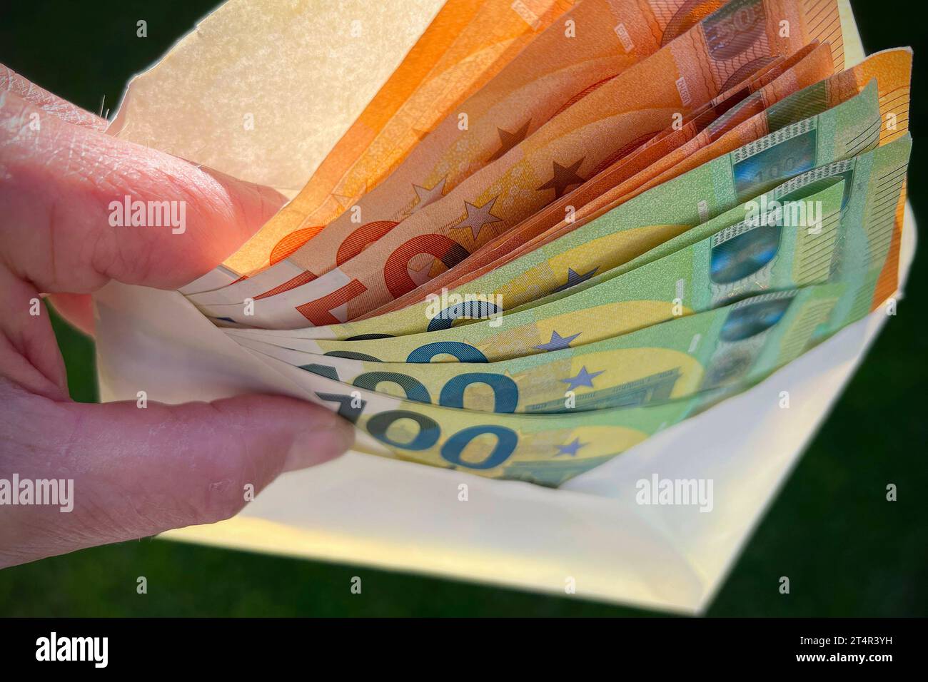 Themenbild,Symbolfoto:Hand greift Geldscheine in einem geoeffneten ...