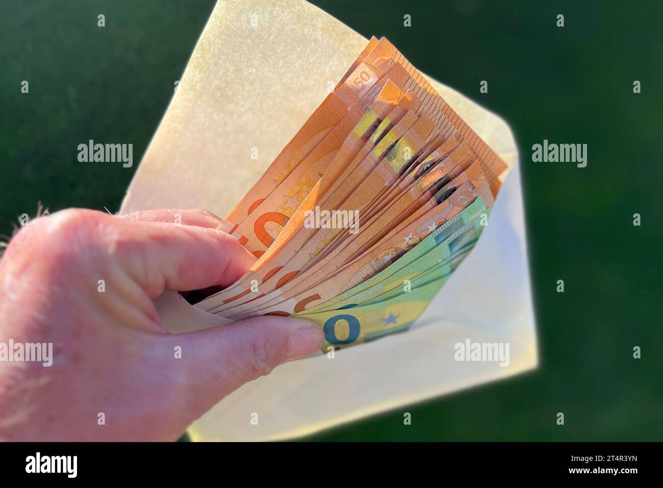 Themenbild,Symbolfoto:Hand greift Geldscheine in einem geoeffneten ...