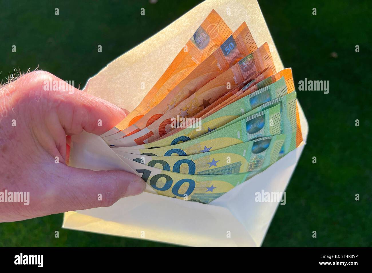 Themenbild,Symbolfoto:Hand greift Geldscheine in einem geoeffneten ...