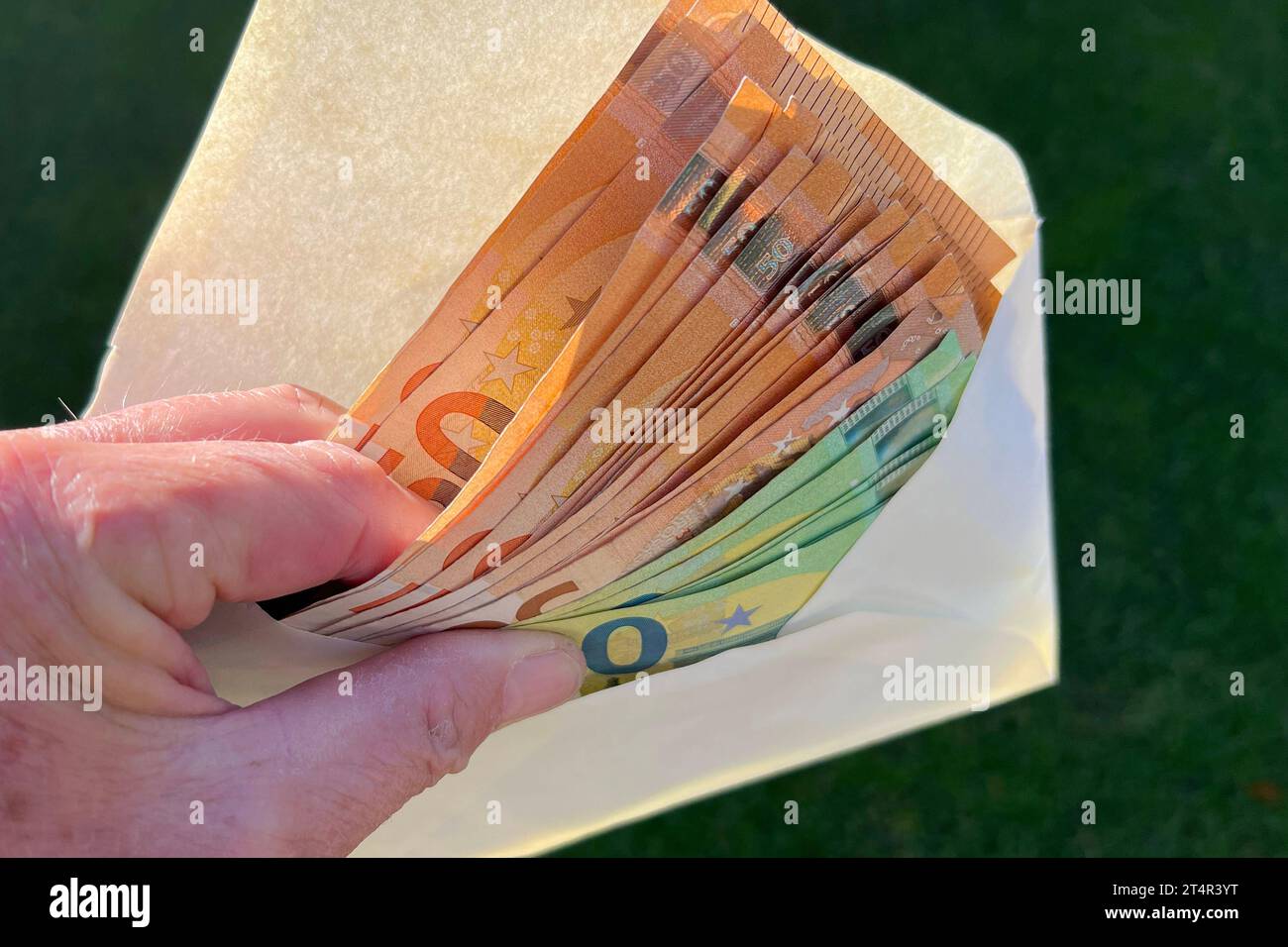 Themenbild,Symbolfoto:Hand greift Geldscheine in einem geoeffneten ...