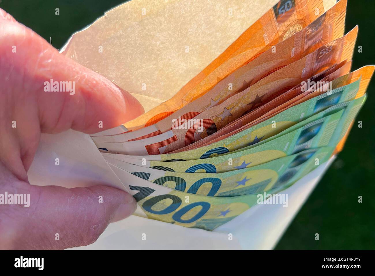 Themenbild,Symbolfoto:Hand greift Geldscheine in einem geoeffneten ...