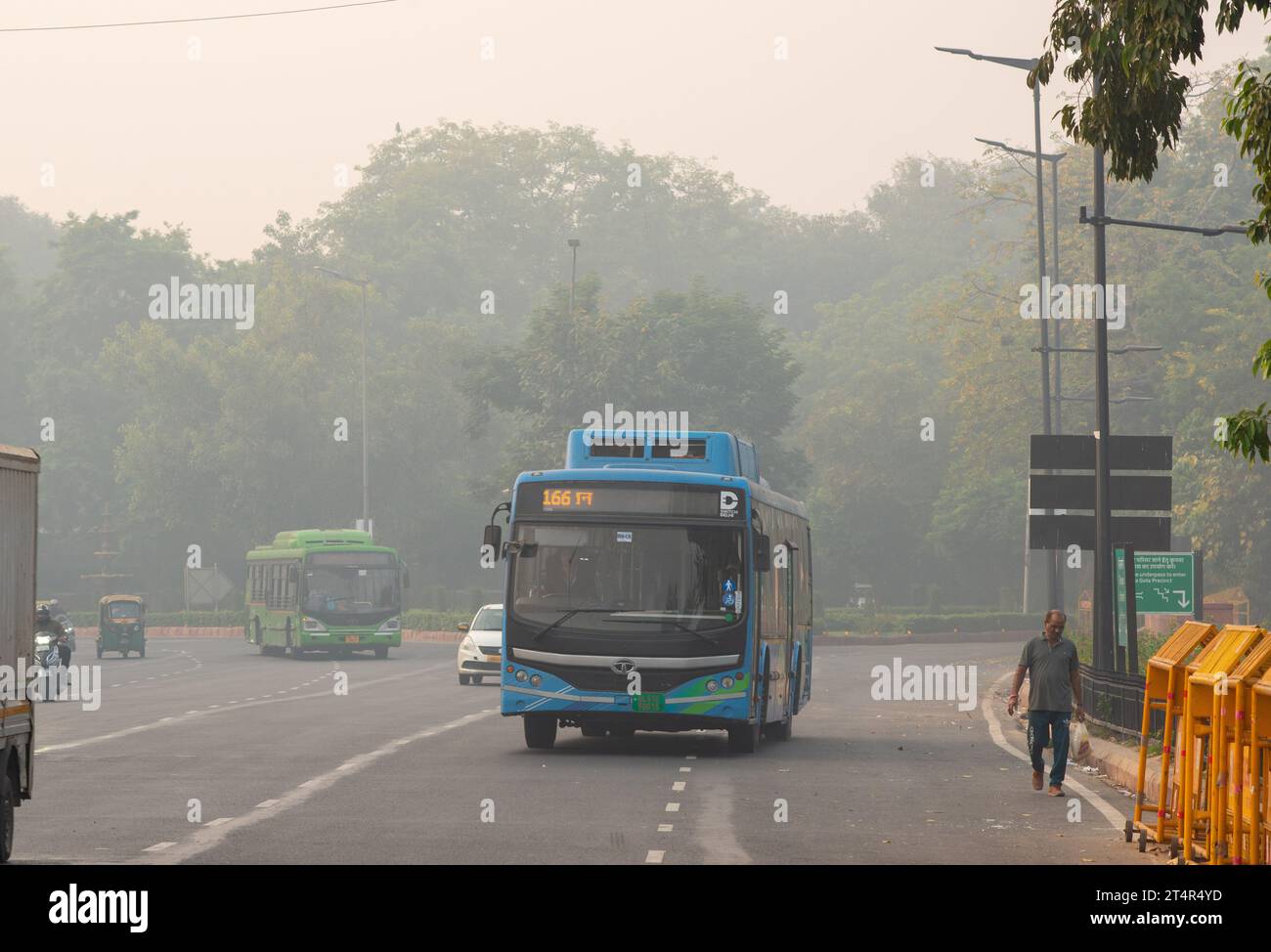 An electric bus navigating through the smog near India Gate, shrouded ...