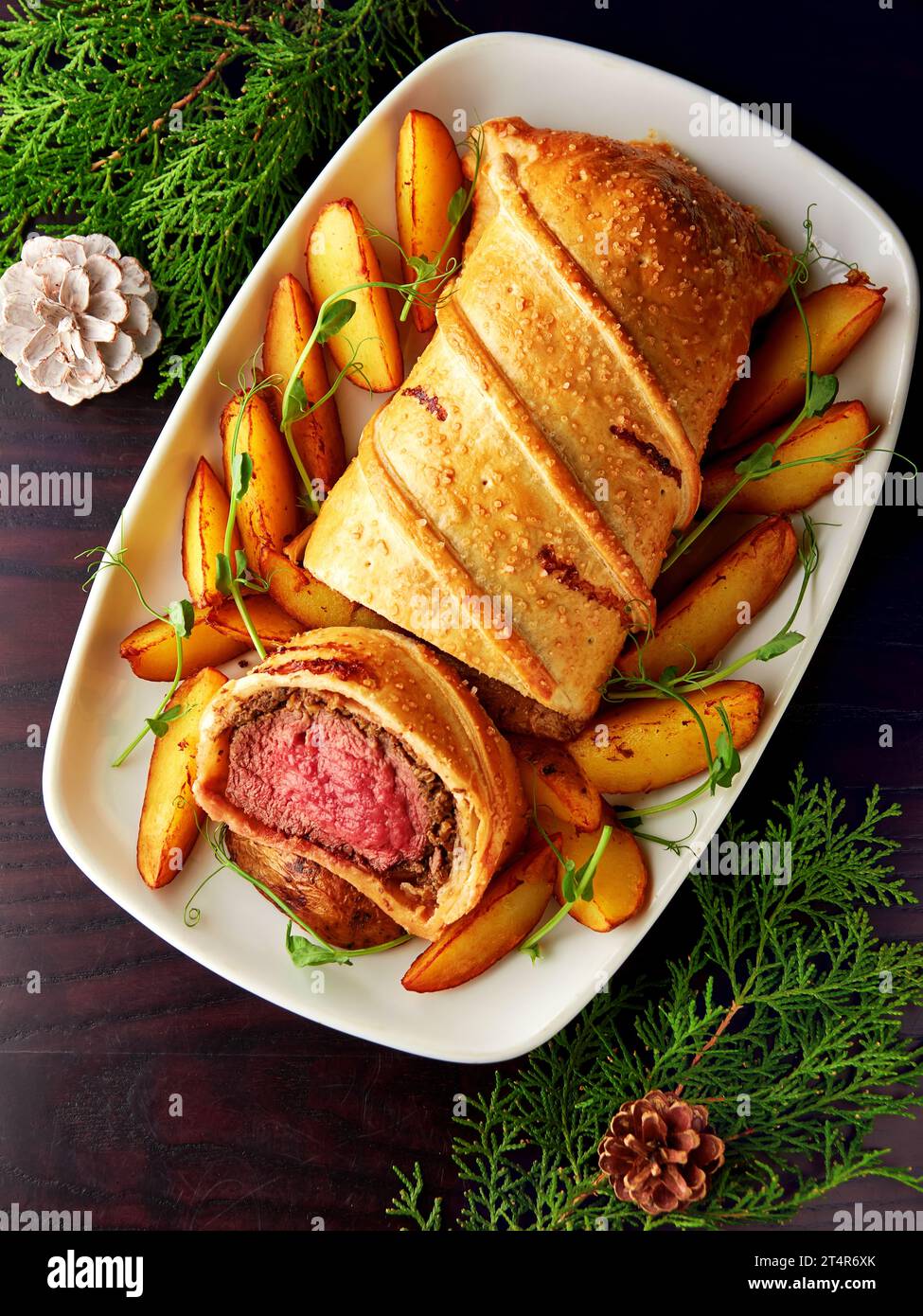 Delicious beef wellington served with baked potato and microgreens ...