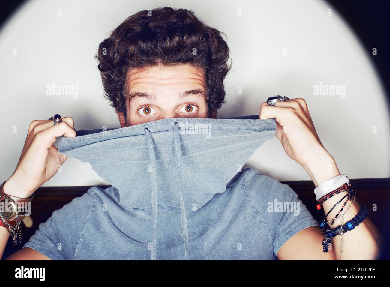 Man, fashion and hiding in studio portrait with clothes, spotlight and ...