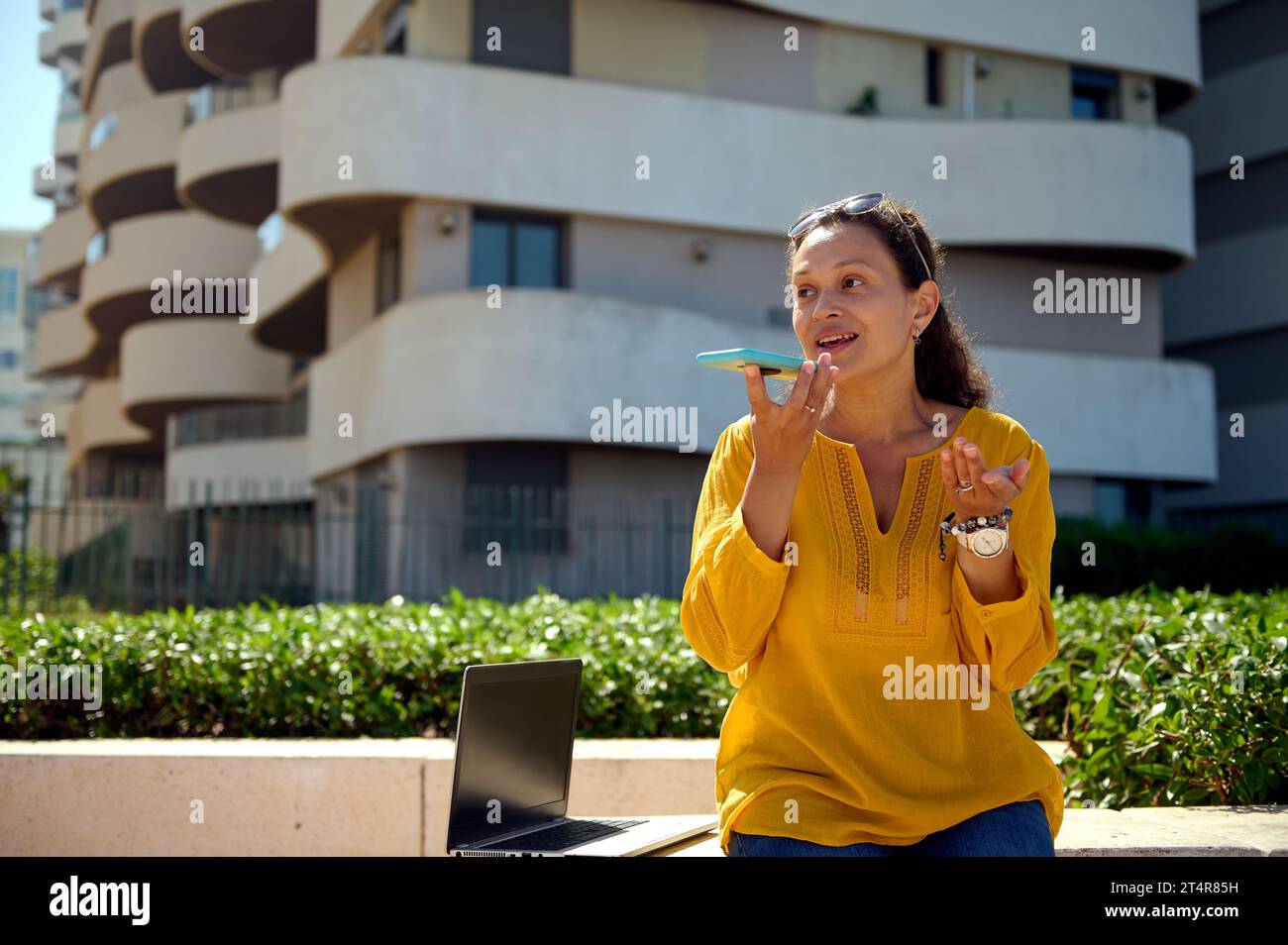 Confident successful young female entrepreneur using smart mobile phone ...