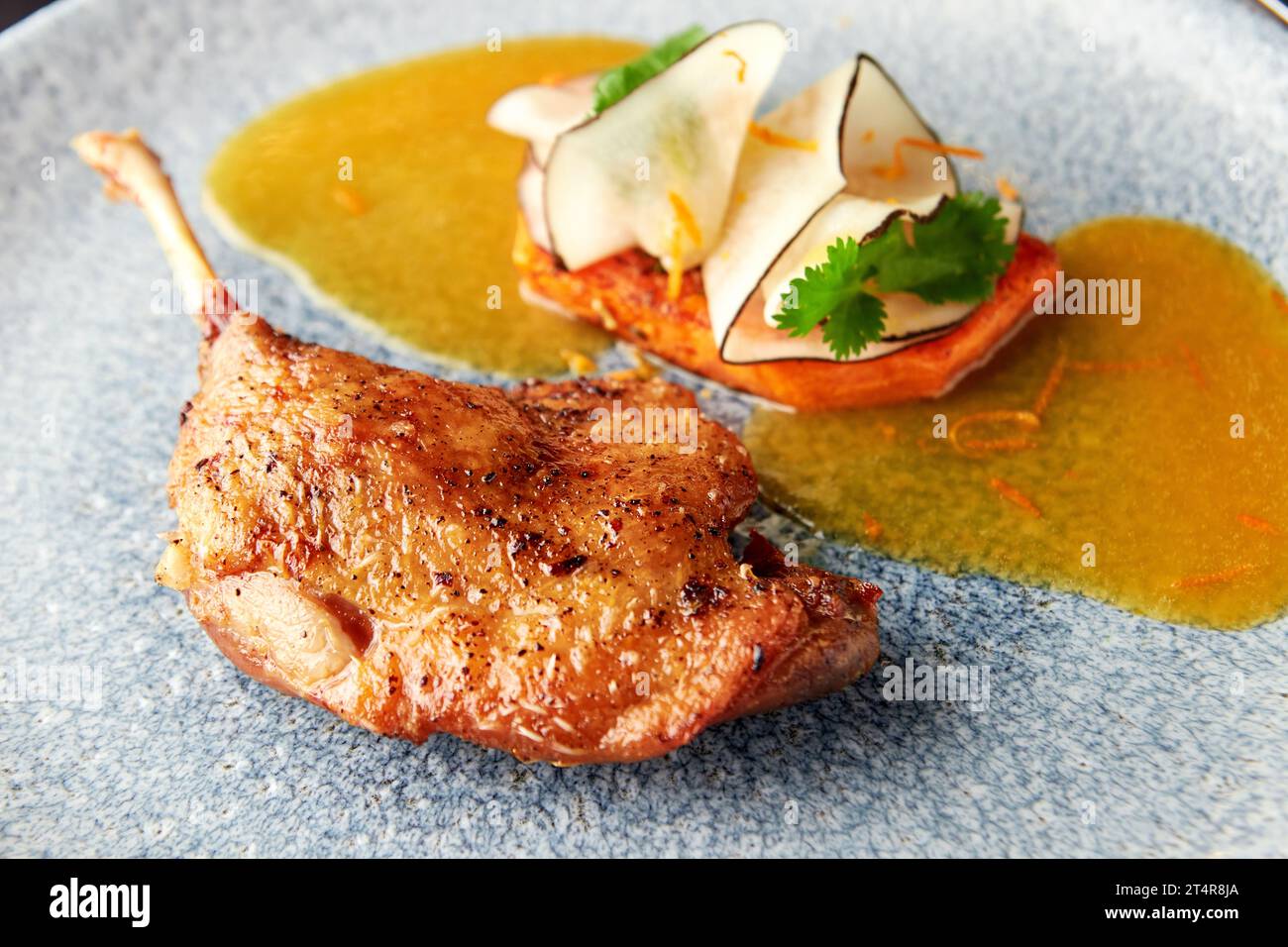 Duck confit served with carrot, black radish and orange sauce. Tasty ...