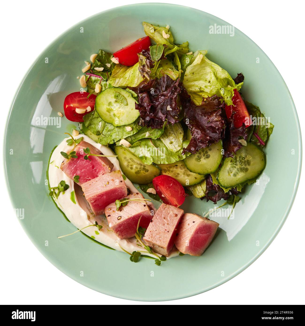 Rare seared tuna slices with fresh vegetable salad in bowl. Isolated on ...
