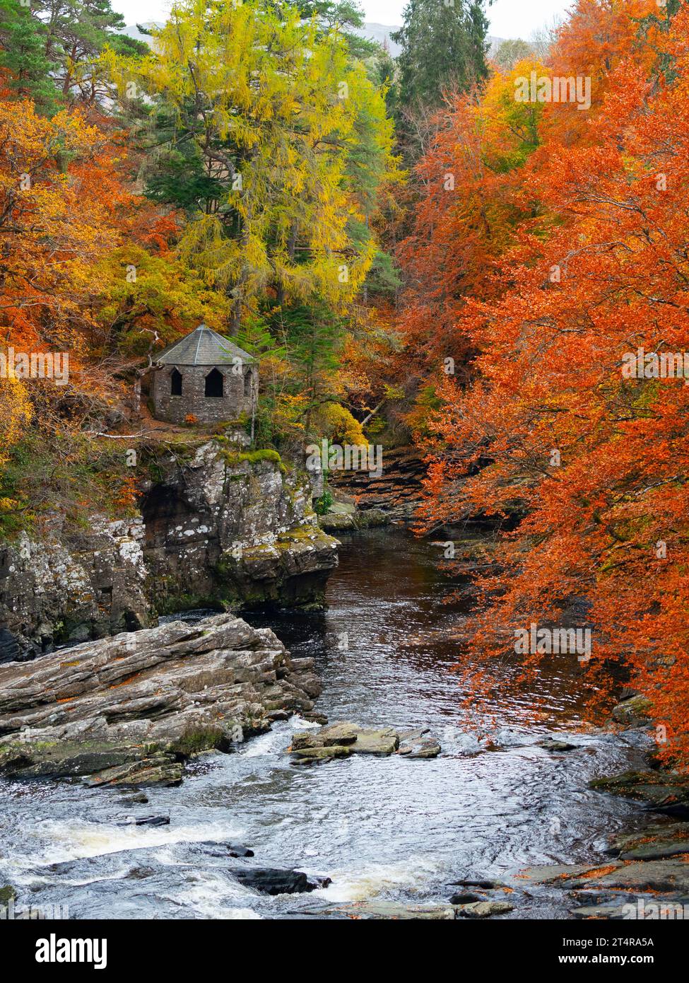 The old summer house beside River Moriston falls with autumn colours in ...
