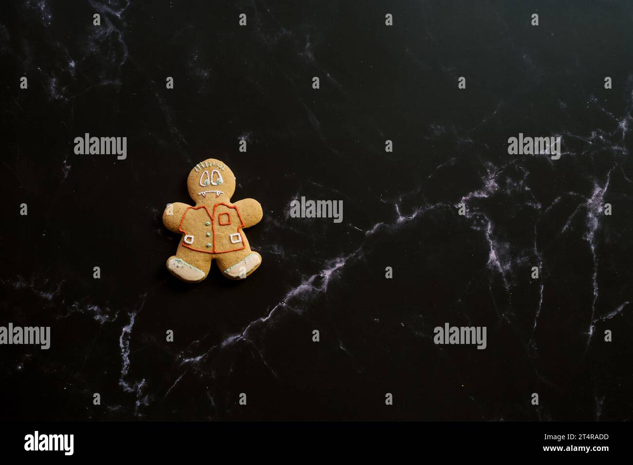 Vampire gingerbread man lies on a black veined marble background Stock ...