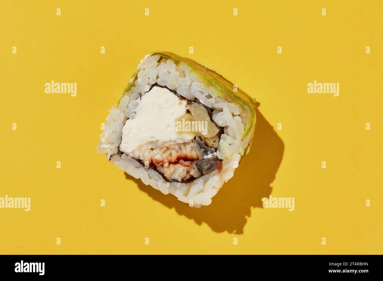 Fresh sushi roll with eel, pineapple, cheese and avocado on yellow ...