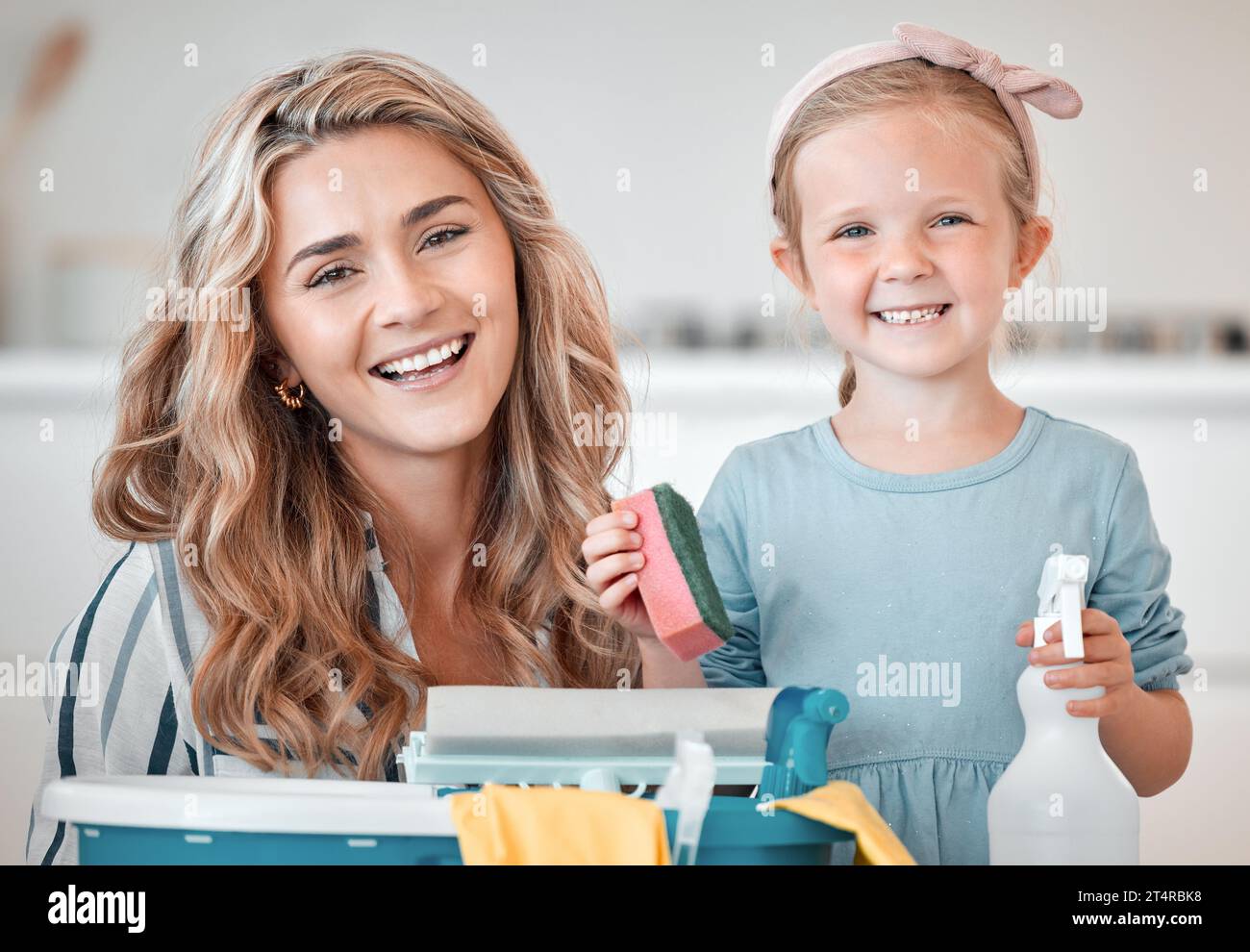 Little caucasian girl helping her mother with household chores at home ...
