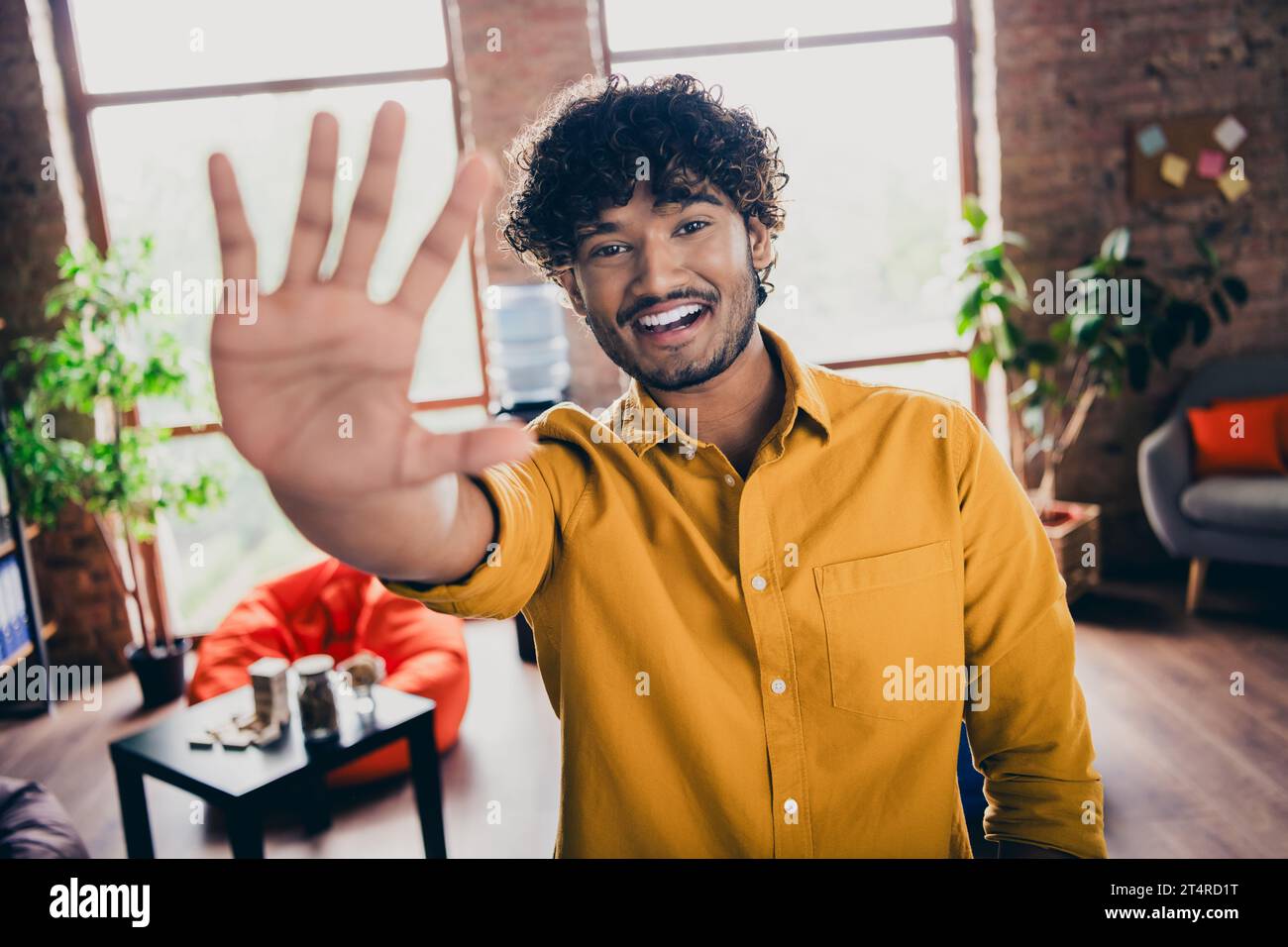 Photo portrait of attractive young man wear yellow shirt wave hand ...