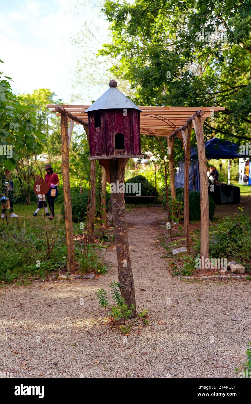 A quaint birdhouse with a metal roof nestled in a natural outdoor ...