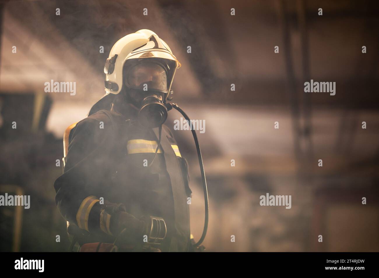 Firefighter portrait wearing full equipment, oxygen mask and chain saw ...