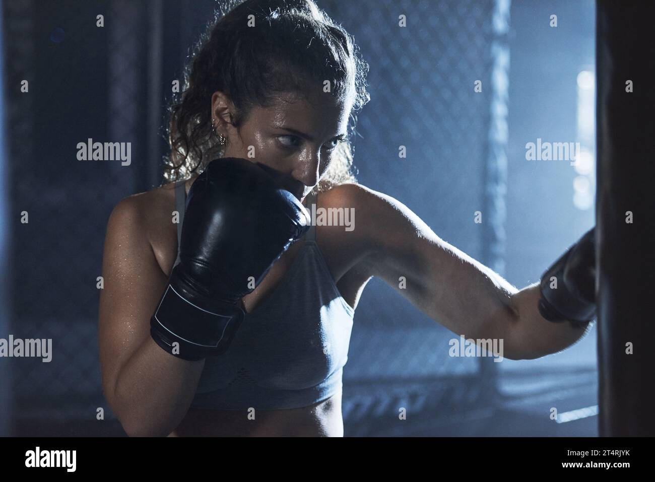 Be strong, be fierce, be empowered. a sporty young woman boxing in a ...