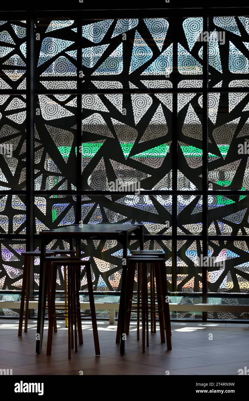 Table and chairs in foyer balcony with exterior seen through aluminium ...