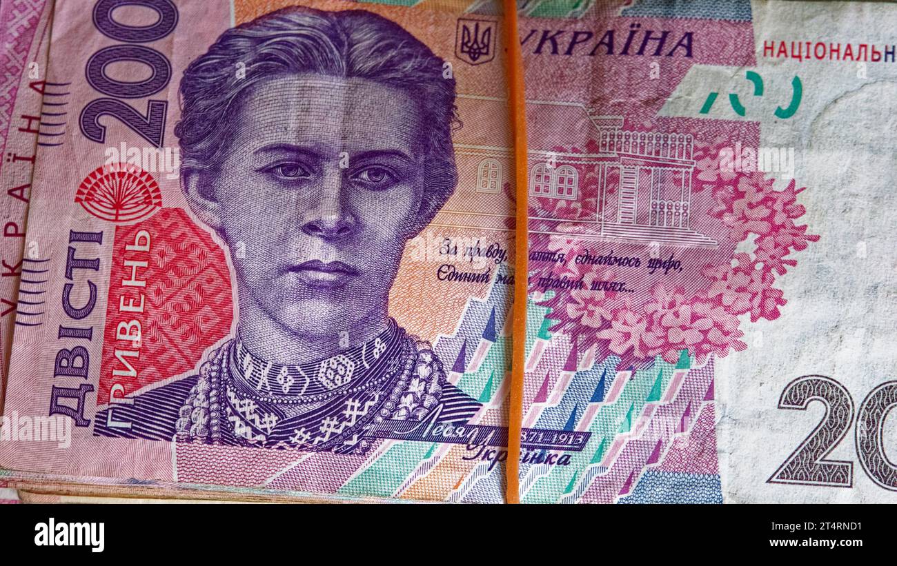A stack of Ukrainian hryvnia banknotes, neatly bound with a rubber band ...