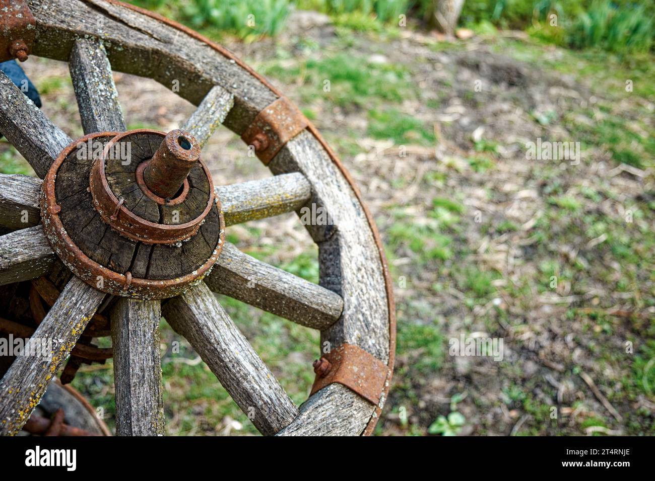 An old, rusted wagon wheel, a relic of a bygone era, lying forgotten in ...