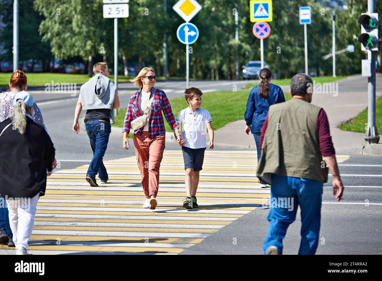 Woman and child cross the road at a pedestrian crossing Stock Photo - Alamy