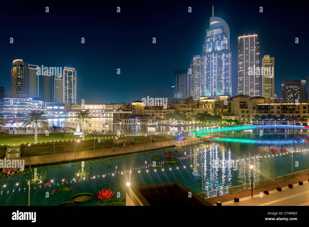 The waters of the Dubai Fountain surrounded by illuminated buildings ...