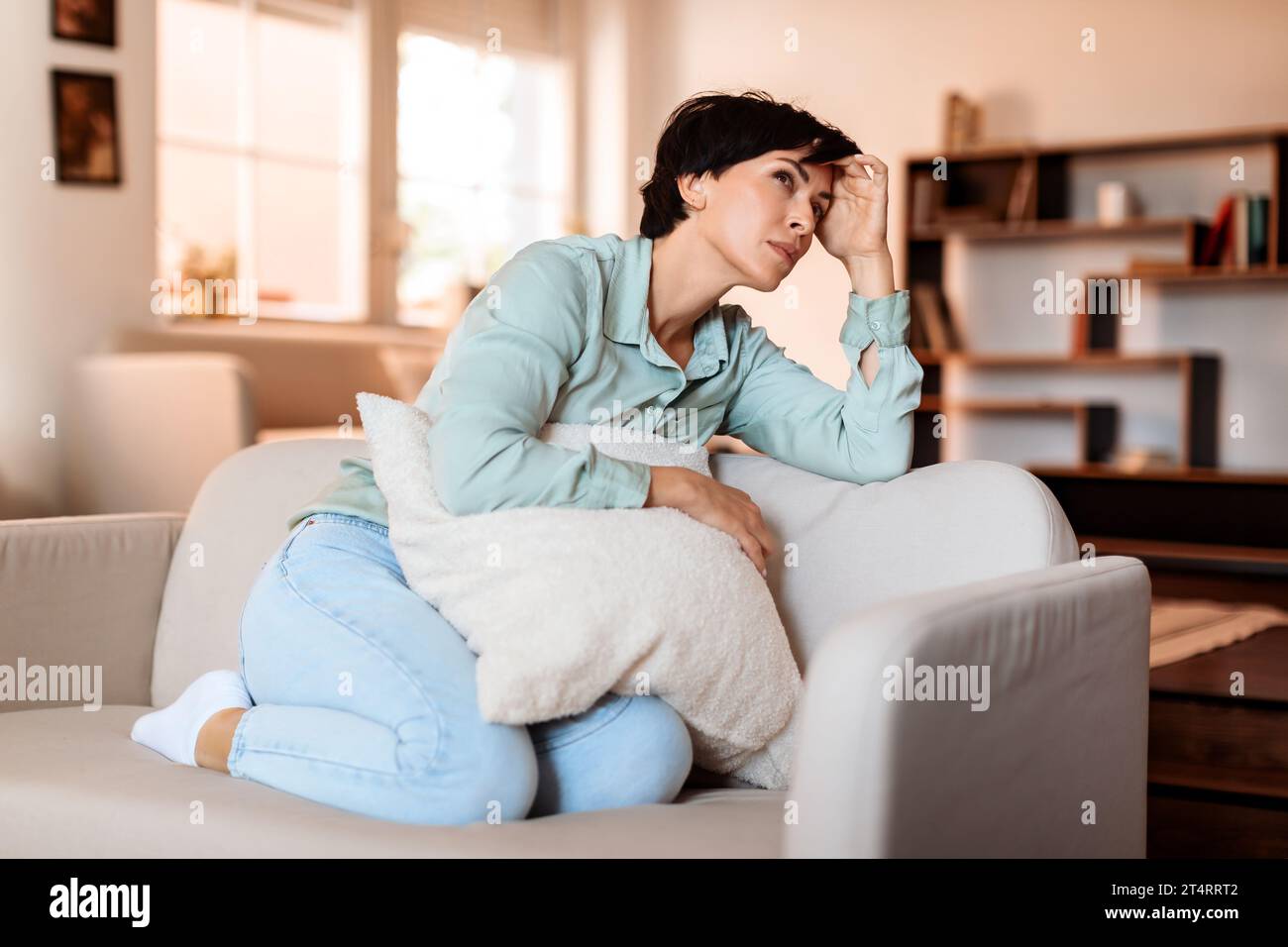 Middle aged woman displaying signs of fatigue and depression indoor ...
