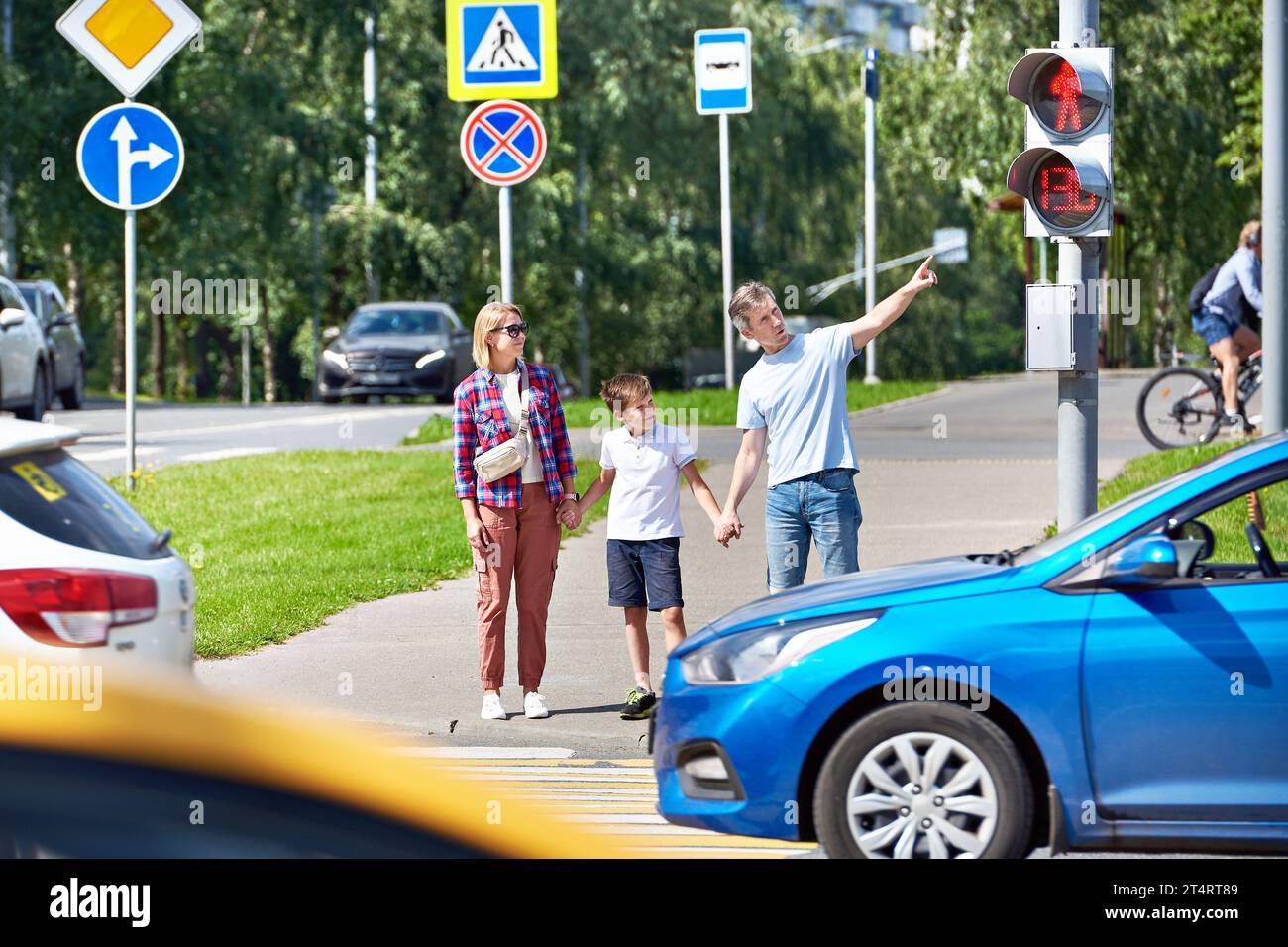 Family, woman, man and child cross the road at a pedestrian crossing ...