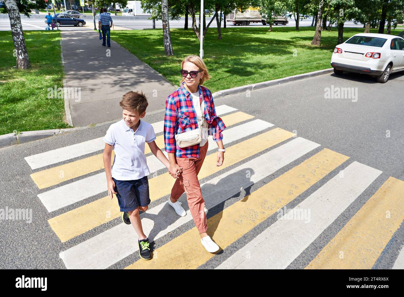 Mother and child walk on pedestrian crossing Stock Photo - Alamy