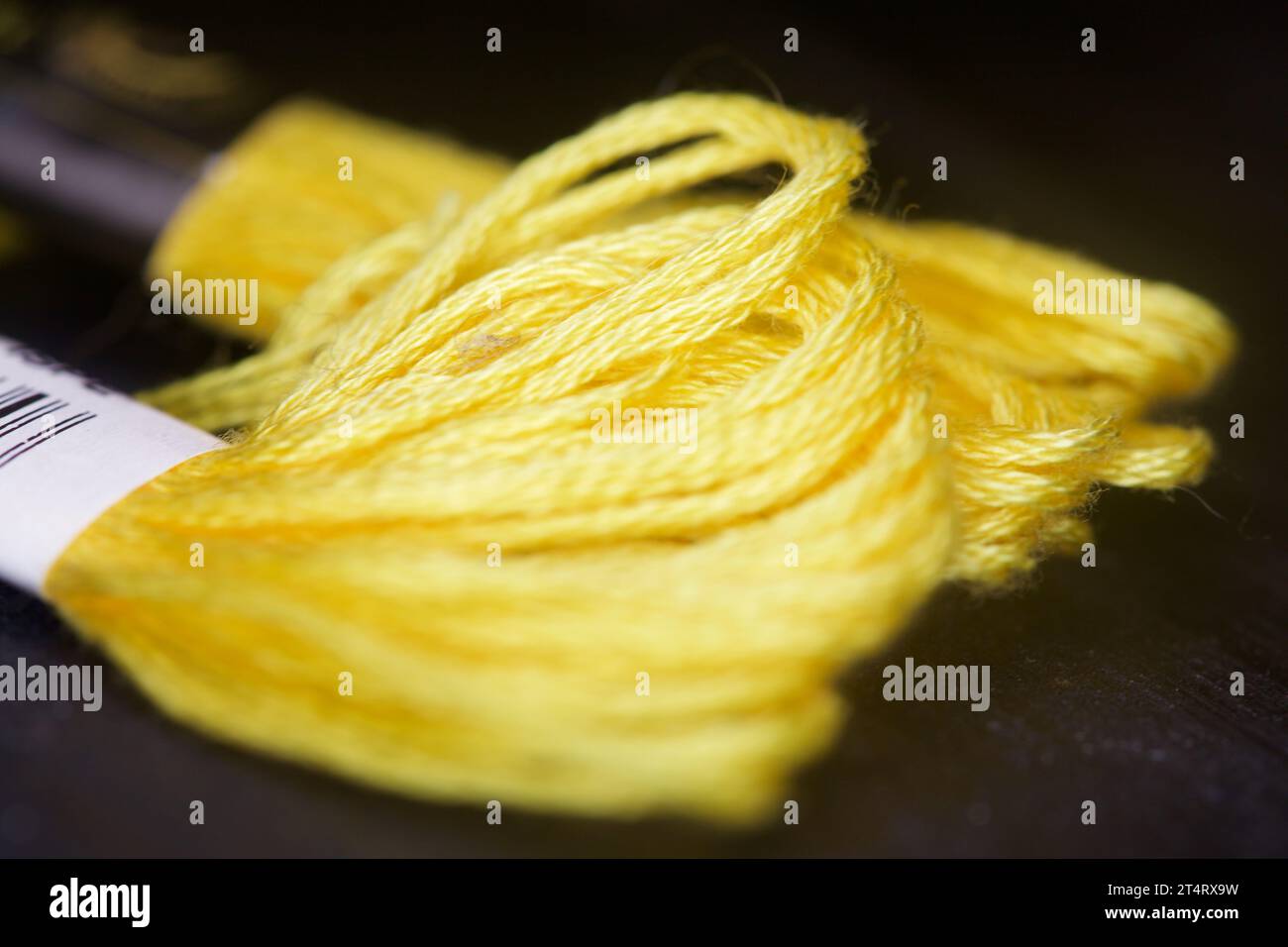Yellow yarn on a black background seen up close Stock Photo - Alamy