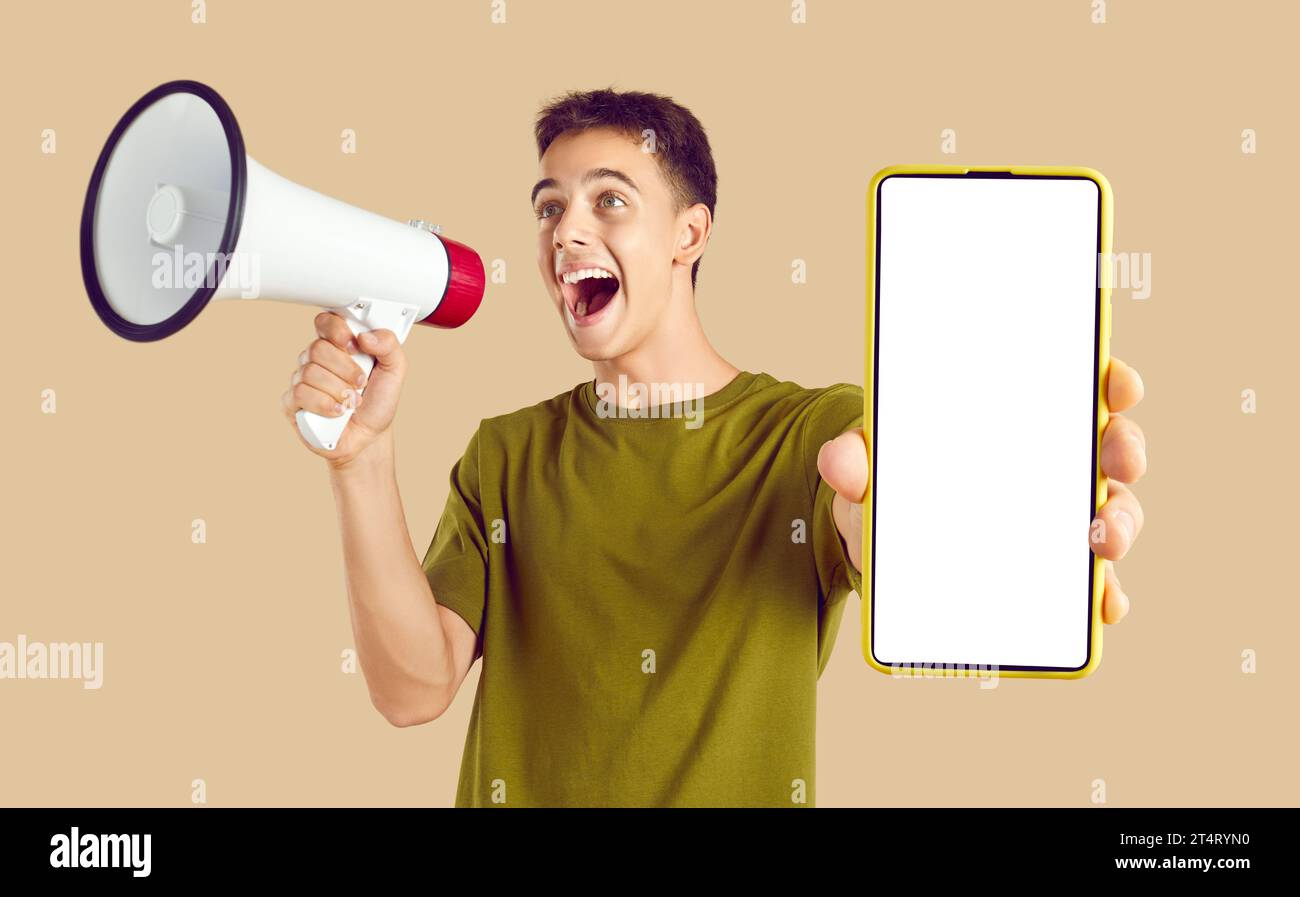 Boy shouting in megaphone, showing big smartphone with empty screen on ...