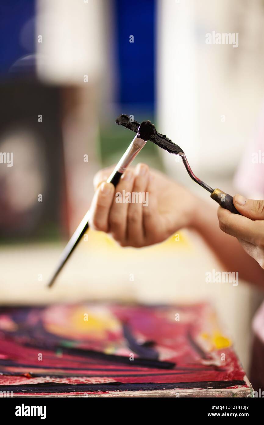 Girl using brush and tool on an artistic painting. Female artist ...