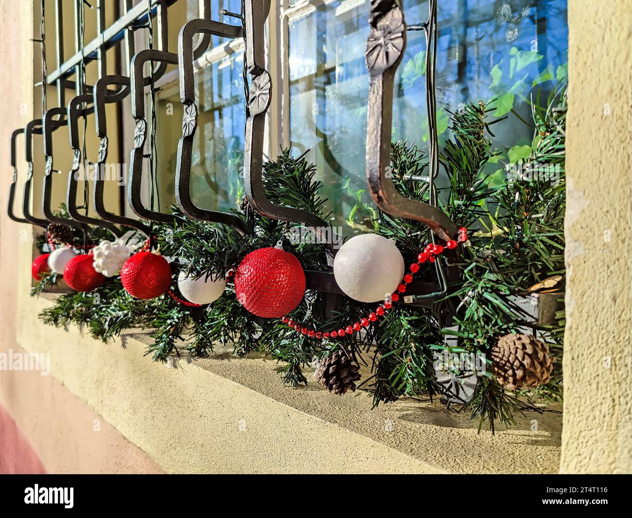 Christmas garland on window with wrought iron bars in old house, winter ...