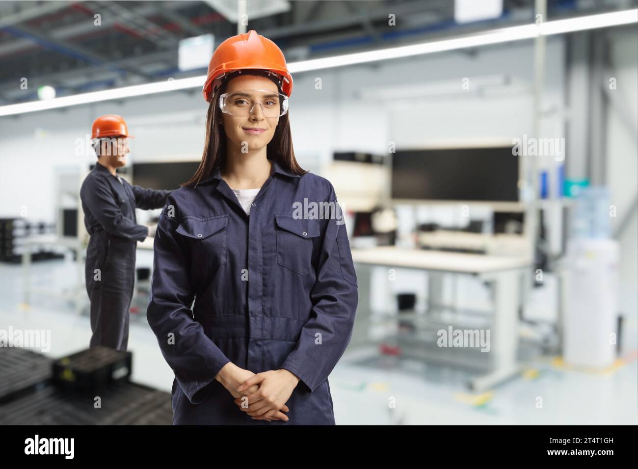 Young female technician with a helmet and goggles at a solar panel ...