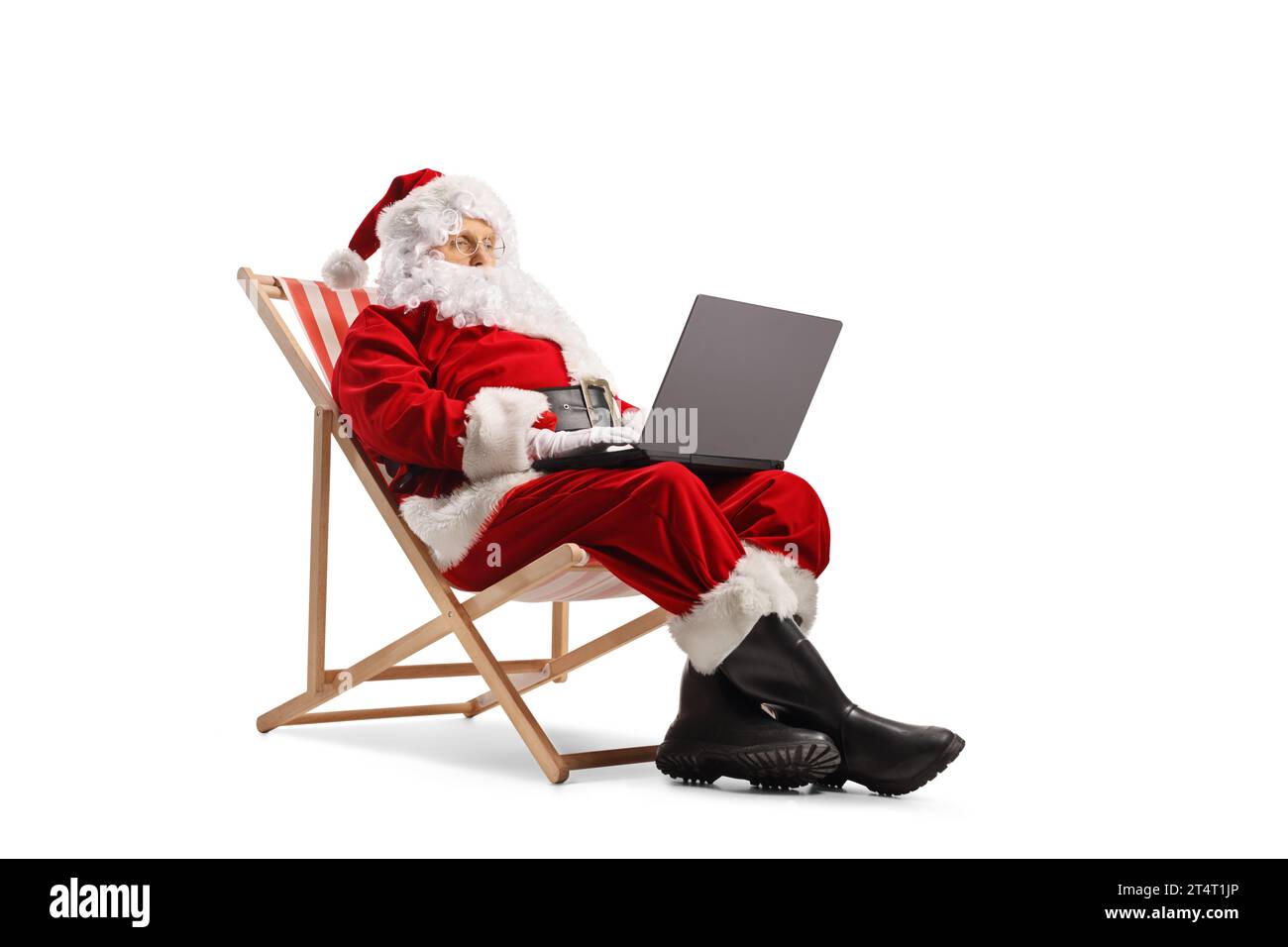 Santa claus and sitting on a deck chair and using a laptop computer ...