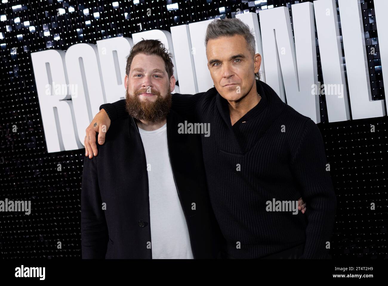 Director Joe Pearlman, left, and Robbie Williams pose for photographers ...
