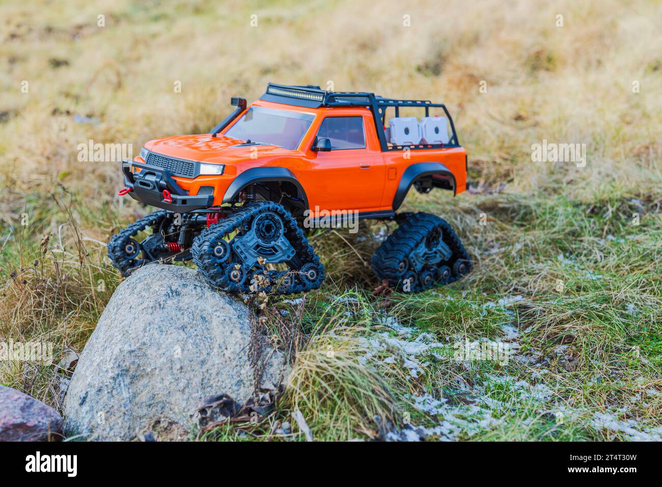 View of orange radio controlled toy off-road vehicle with caterpillar ...