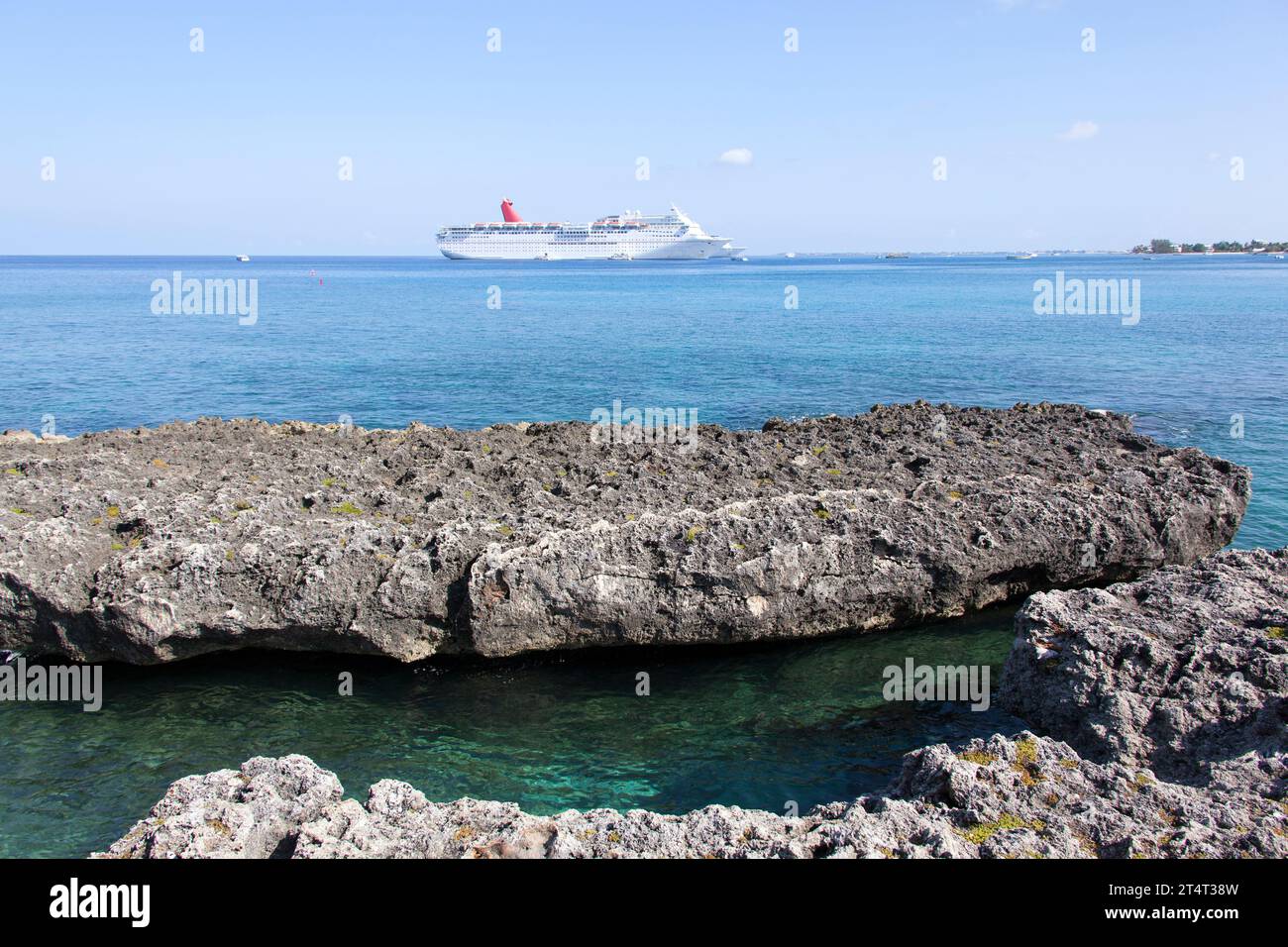 The morning view of Grand Cayman island rocky shore with a cruise ship ...