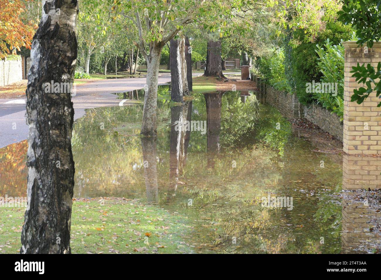 Excessive autumn rainwater creating flooding and reflections on road ...