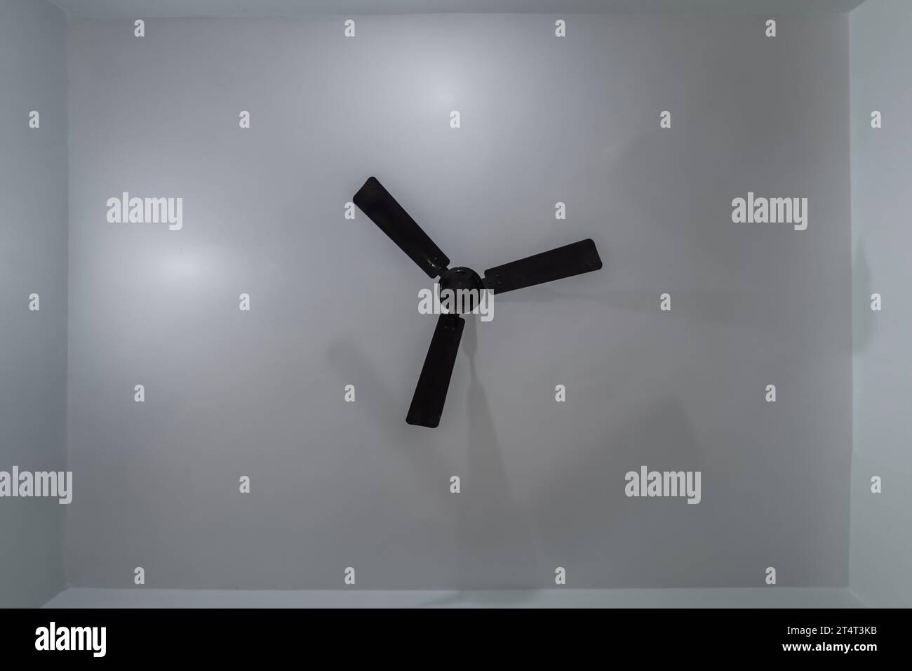 bottom up view of a ceiling air fan in an empty room for cooling the ...