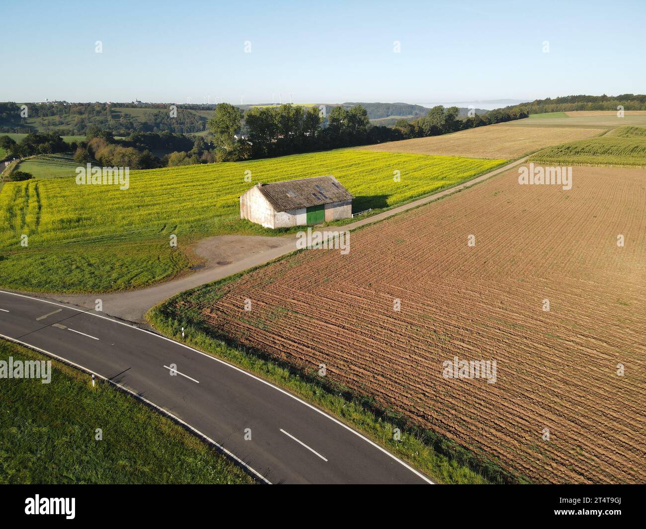 Aerial view of a landscape with country fields, forest trees, a curved ...