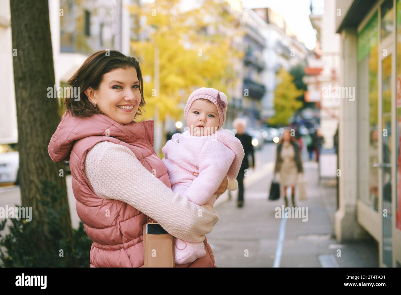 Outdoor portrait of happy young mother holding cute little baby girl, winter in Europe, Montreux ...