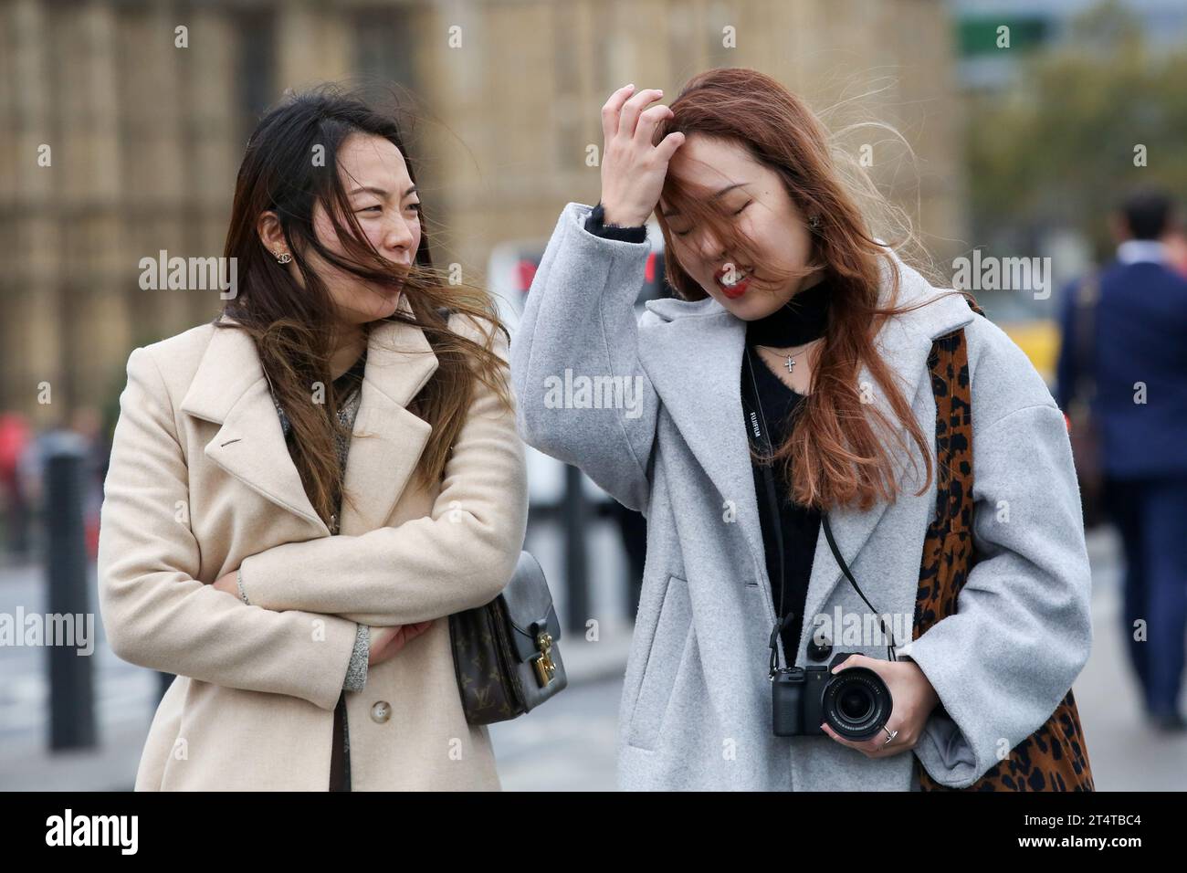 Women are seen on Westminster Bridge in central London during windy ...