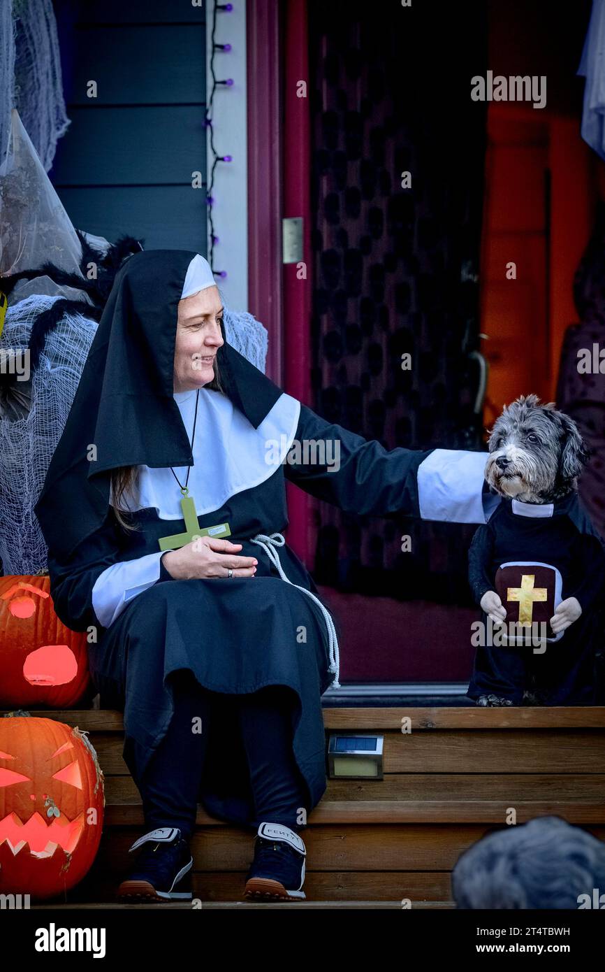 Halloween, Nun on front porch with dog as Priest Stock Photo - Alamy