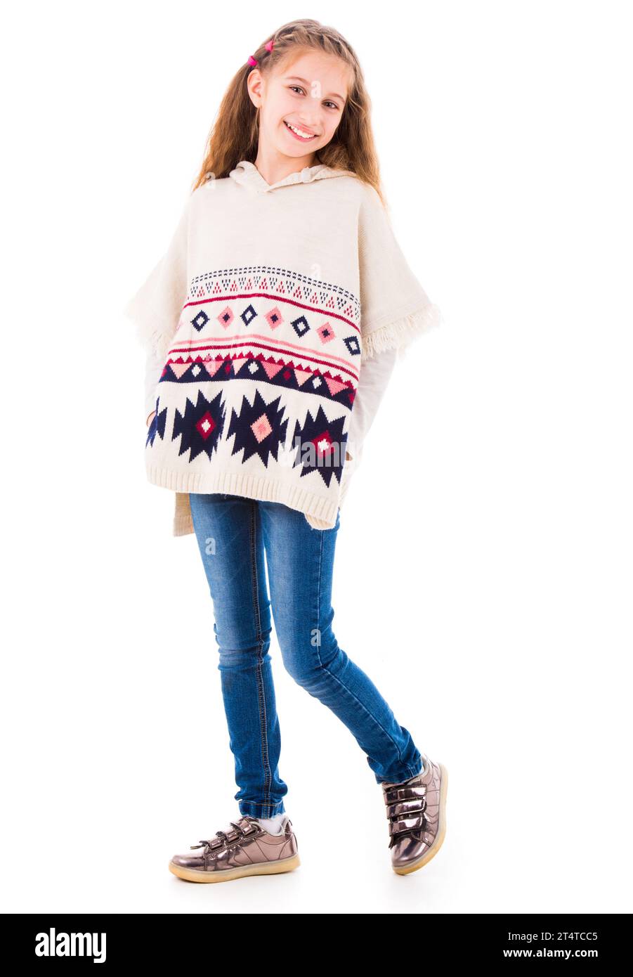 Smiling adorable little girl posing in warm beige poncho and jeans ...