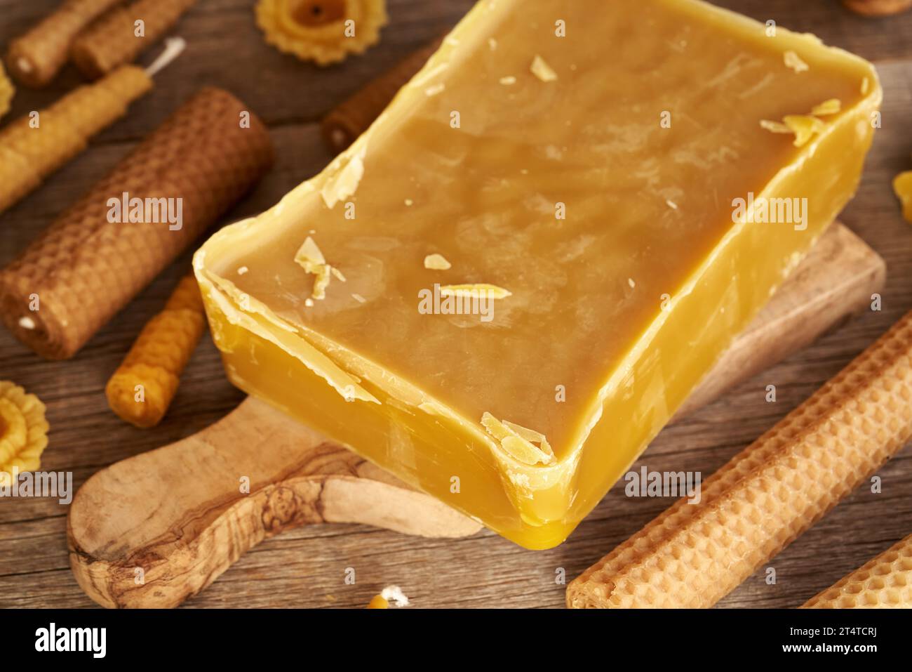 A block of bees wax with handmade candles on a table Stock Photo - Alamy