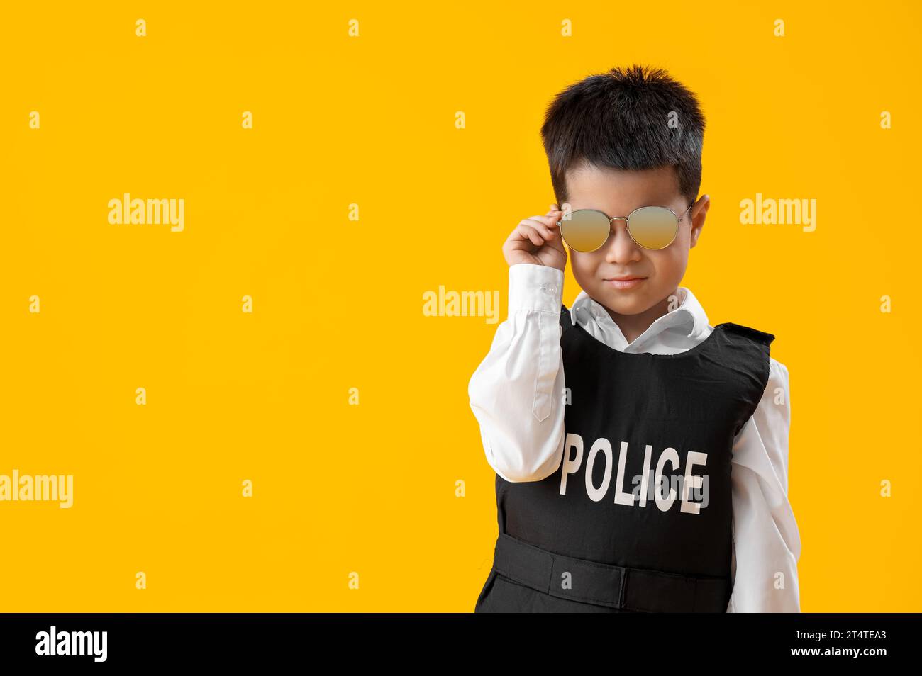Cute little policeman on yellow background Stock Photo - Alamy