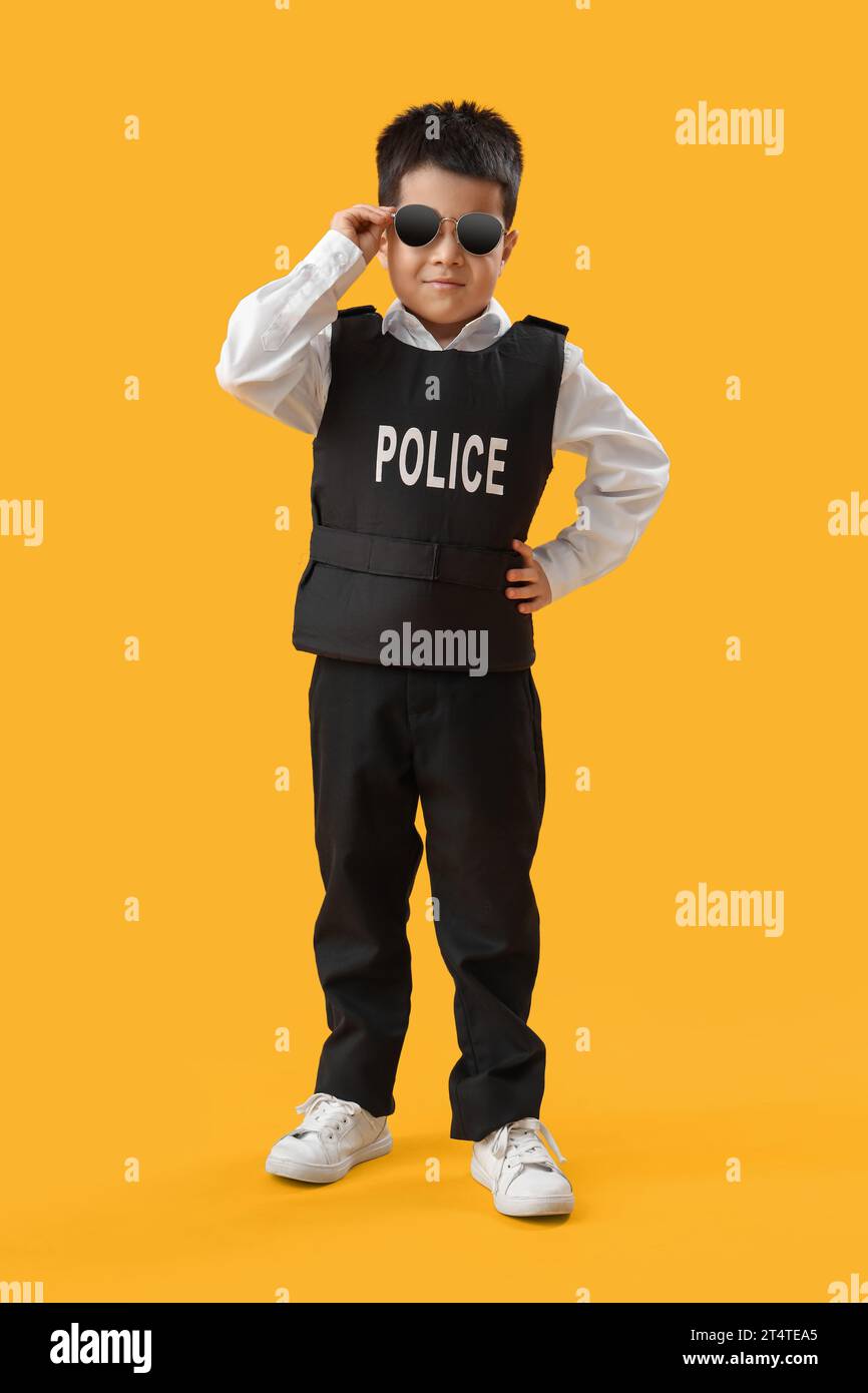 Cute little policeman on yellow background Stock Photo - Alamy