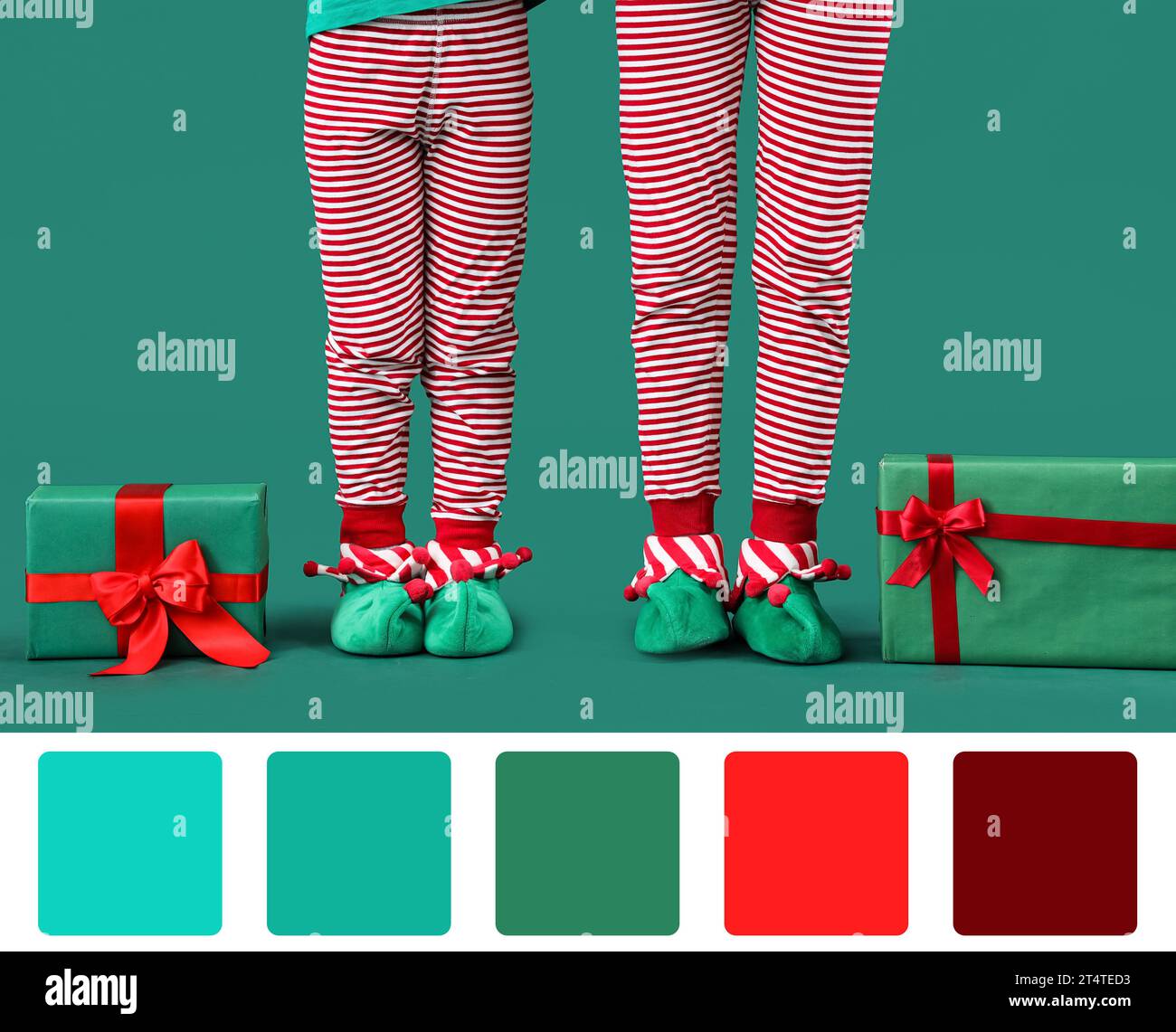 Legs of little children in elves costumes and with Christmas gifts on ...