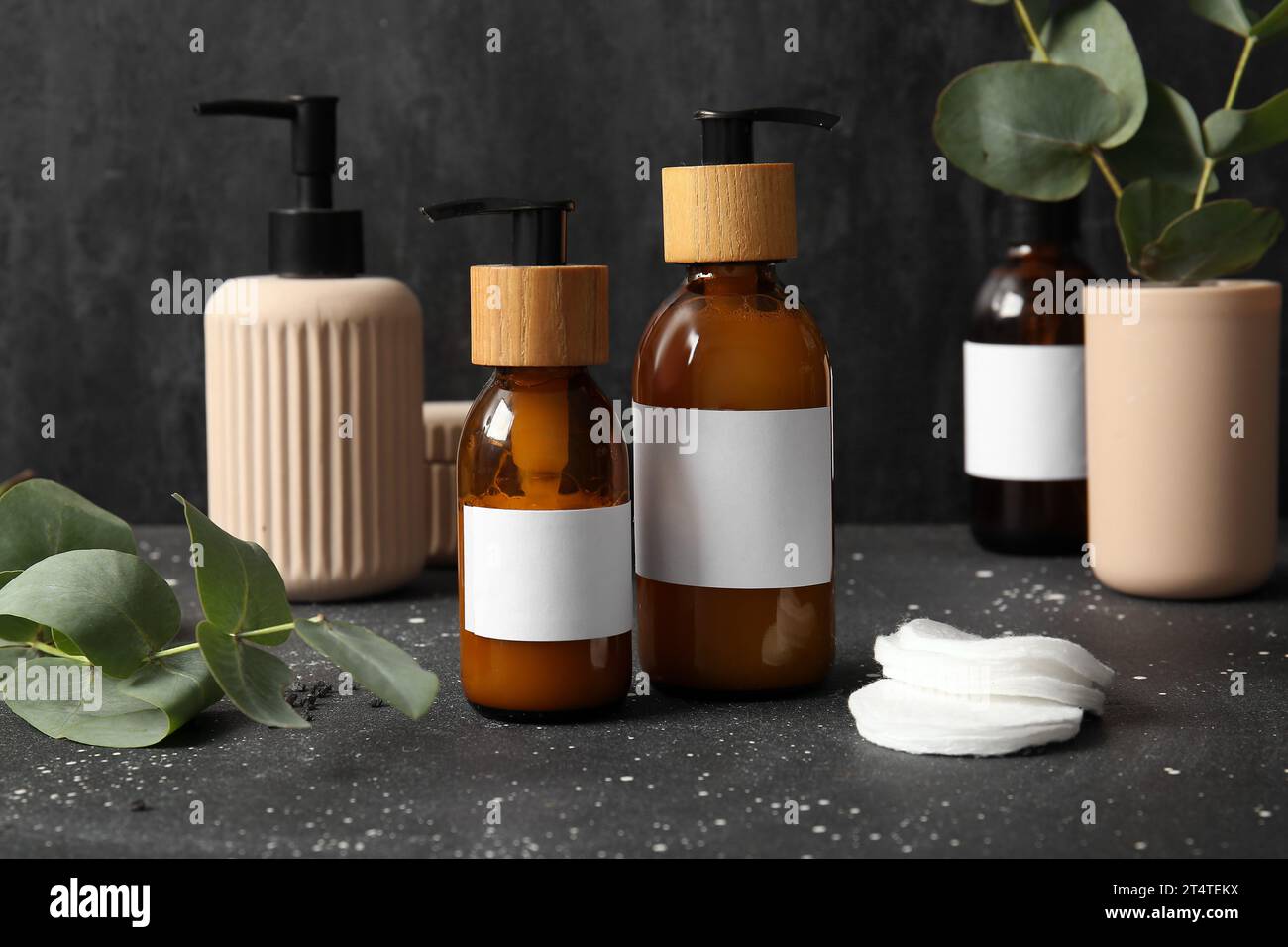 Bottles of shampoo and cotton pads on black background Stock Photo - Alamy